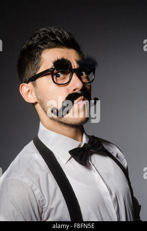 Funny guy with moustache and bow-tie fake meditating, peeking aside ...