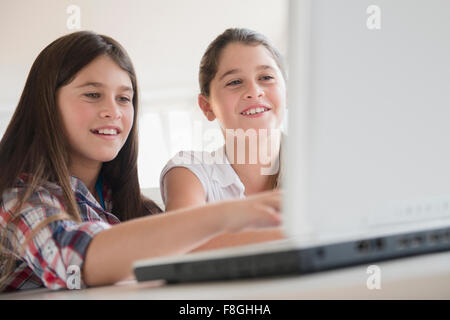 Sisters using laptop computer Stock Photo - Alamy