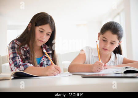 Caucasian twin sisters doing homework Stock Photo - Alamy