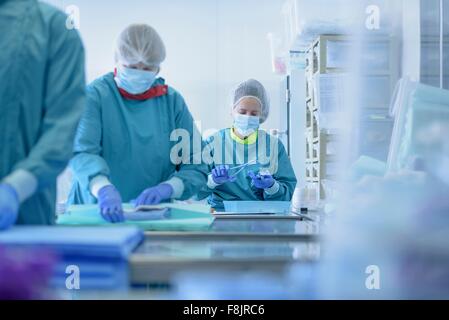 Workers inspecting surgical instruments in clean room of surgical ...
