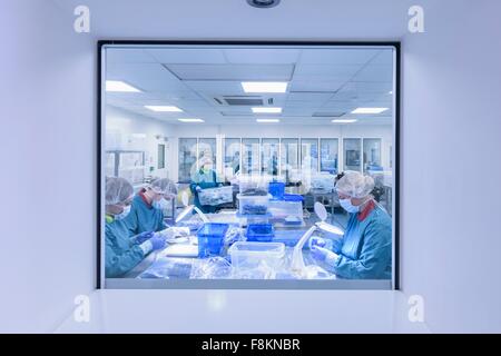 Workers inspecting surgical instruments in clean room of surgical ...