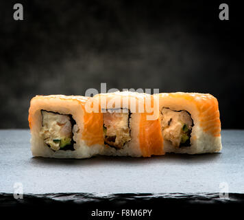 Delicious sushi on a black textured chalkboard. Sushi set on a black ...