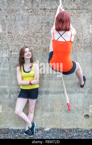 Woman climbing over over wall Stock Photo - Alamy