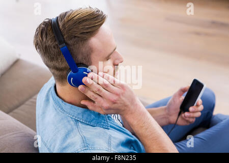 Casual young man listening music with headphones, isolated on white ...