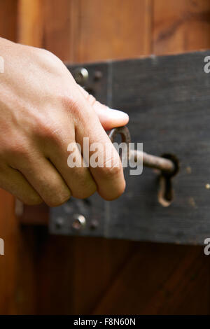 Hand Turning Key In Old Fashioned Lock Stock Photo - Alamy