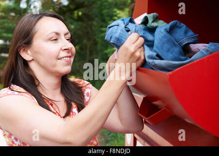 Woman Recycling Old Clothes At Clothes Bank Stock Photo - Alamy