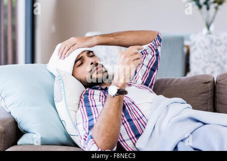 Sick man checking his temperature Stock Photo - Alamy