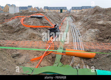 Pipe and cables in trench at road crossing laying pipelines. Building ...