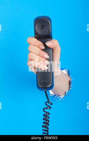 Hand with phone out of paper hole Stock Photo - Alamy