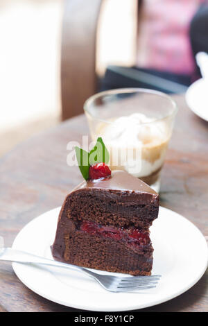 Chocolate cake on white plate over wooden table Stock Photo - Alamy