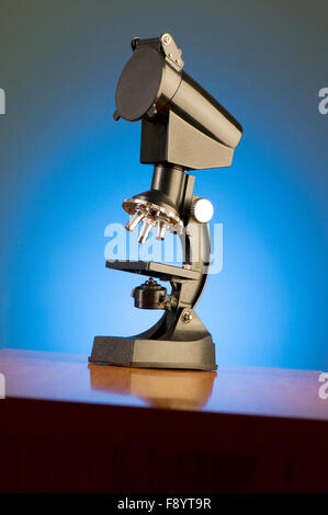 Microscope against blue gradient background Stock Photo - Alamy