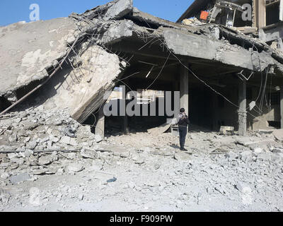 Fallujah, Iraq. 12th Dec, 2015. A man and two boys walk past destroyed ...