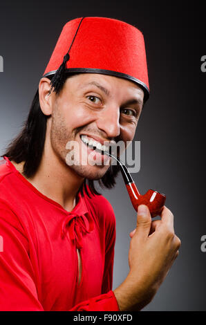 Man wearing fez hat, smoking narghile at Neveshir, Turkey. A hookah ...