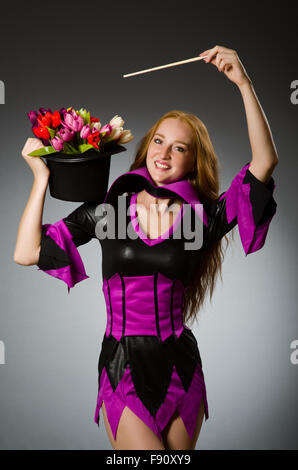 Female magician doing tricks on grey background Stock Photo - Alamy