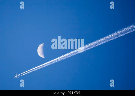 Airplane Flying Past The Moon Against Bright Blue Sky Stock Photo - Alamy