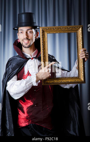 Magician with photoframe in studio Stock Photo - Alamy