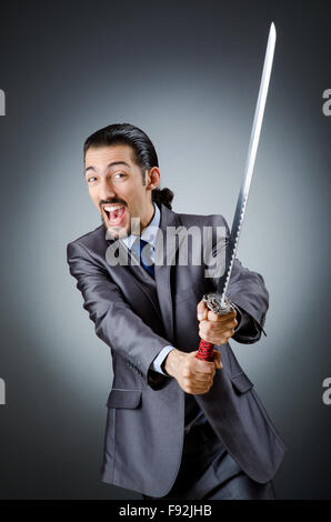 Angry businessman with sword in dark room Stock Photo - Alamy