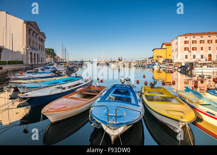 Boats are anchored in clear blue water near the harbor of Riomaggiore ...