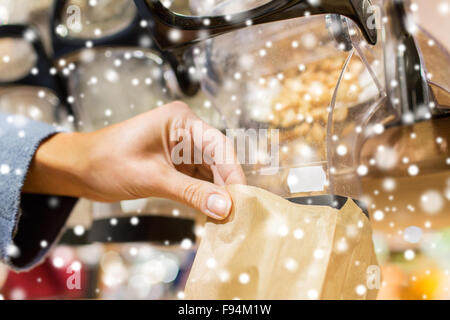 close up of hand pouring nuts to paper bag Stock Photo - Alamy