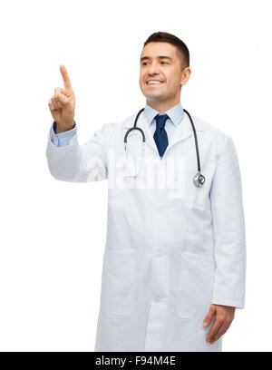 Smiling doctor with stethoscope pointing at something on white ...