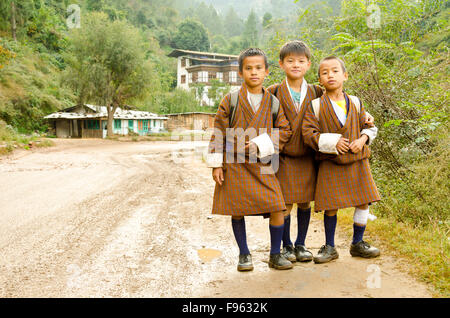 Bhutanese boys in traditional dress the gho, a knee-length robe tied ...