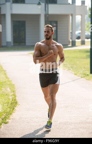 Young Bodybuilder Running In Park Area - Training And Exercising For ...