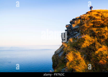 A hiker on Vaeroy Island, Lofoten Islands, Norway, with Mosken (right ...