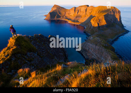 A hiker on Vaeroy Island, Lofoten Islands, Norway, with Mosken (right ...
