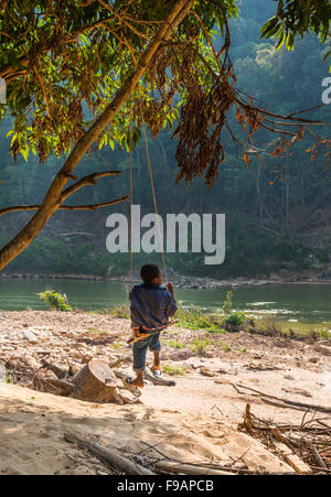 Young boy, aboriginal Orang Asil, holding his crying baby brother in ...