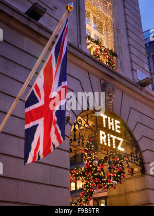 The Ritz Hotel at Christmas with Union Jack flag shoppers and passing ...