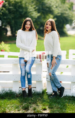 Two girls lean bench Stock Photo - Alamy