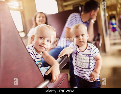 Young family with two children at train station. The family passes ...