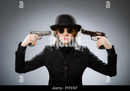 Female spy with weapon against gray Stock Photo - Alamy