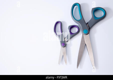 two pair of scissors which one big and small on the white background ...