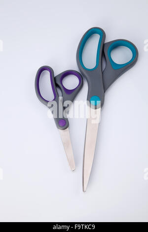 two pair of scissors which one big and small on the white background ...