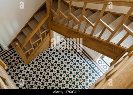 Looking down staircase at hall with wooden flooring and stained-glass ...