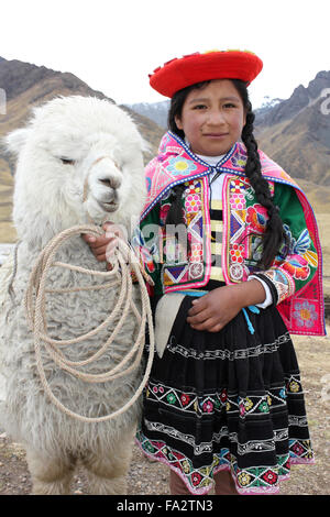 A person wearing traditional Andean clothing walks down a cobblestone ...
