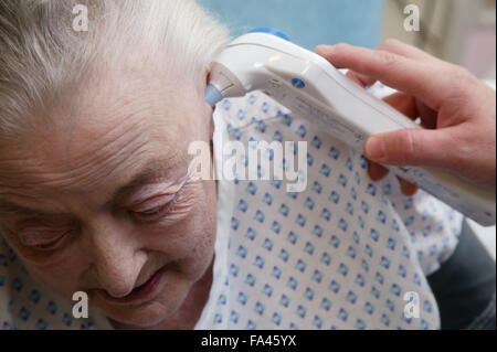 Elderly woman having her temperature checked Stock Photo - Alamy