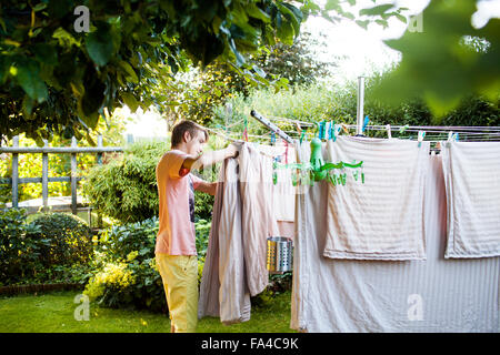 Teenage boy doing the laundry in a public laundromat Stock Photo ...