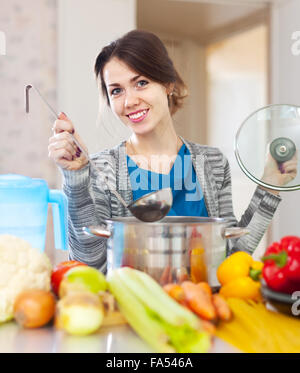woman cooking veggie soup with laddle in kitchen Stock Photo - Alamy