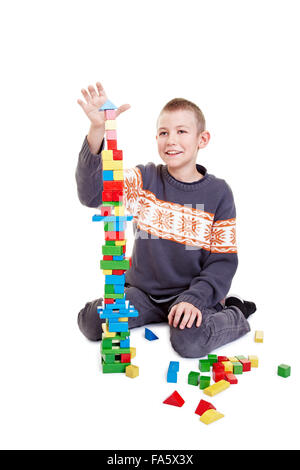 Boy building carefully a tower with building bricks Stock Photo - Alamy
