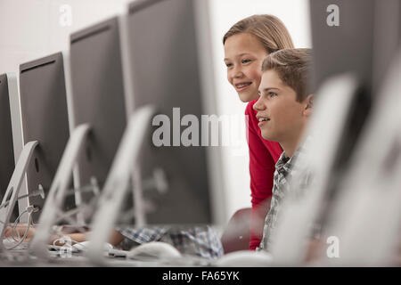 Computer room, 4 people looking at screens Stock Photo - Alamy