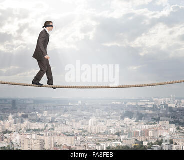 Man walking gingerly with band on his eyes Stock Photo - Alamy