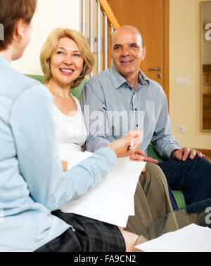 happy couple discussing details of private insurance with agent at ...