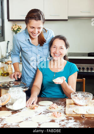 Two women cooking meat pasties at home kitchen Stock Photo - Alamy