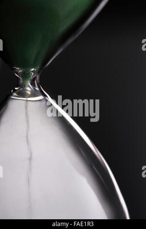 Sand funneling through hour glass Stock Photo - Alamy
