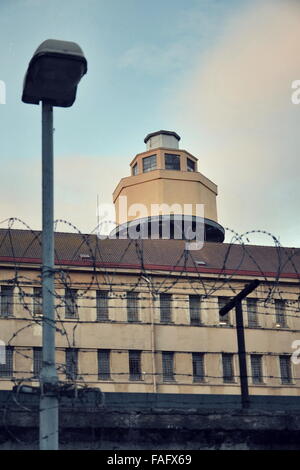 Barbed wire security fence around large circular fuel storage tanks ...