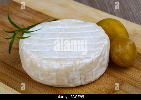 Round Brie cheese with yellow plums and estragon Stock Photo - Alamy