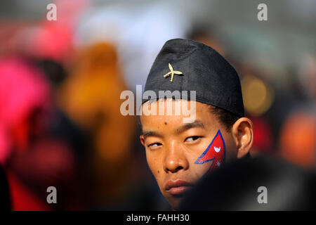 A Gurung youth in a traditional attire face painted Flag of Nepal ...