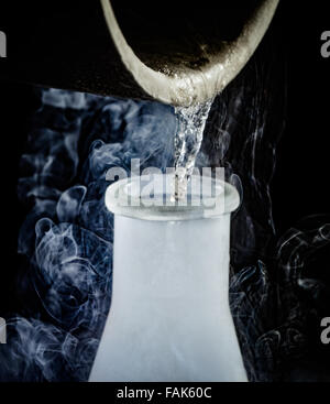 Liquid being poured from beaker into test tube Stock Photo - Alamy